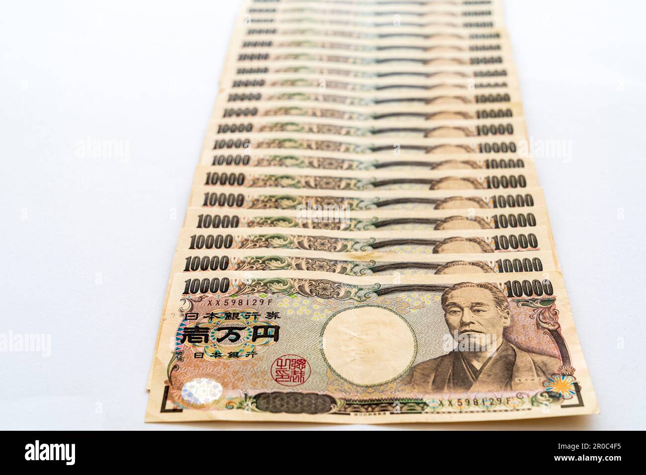 Japanese 10,000 yen banknotes overlapping each other in a long line on ...