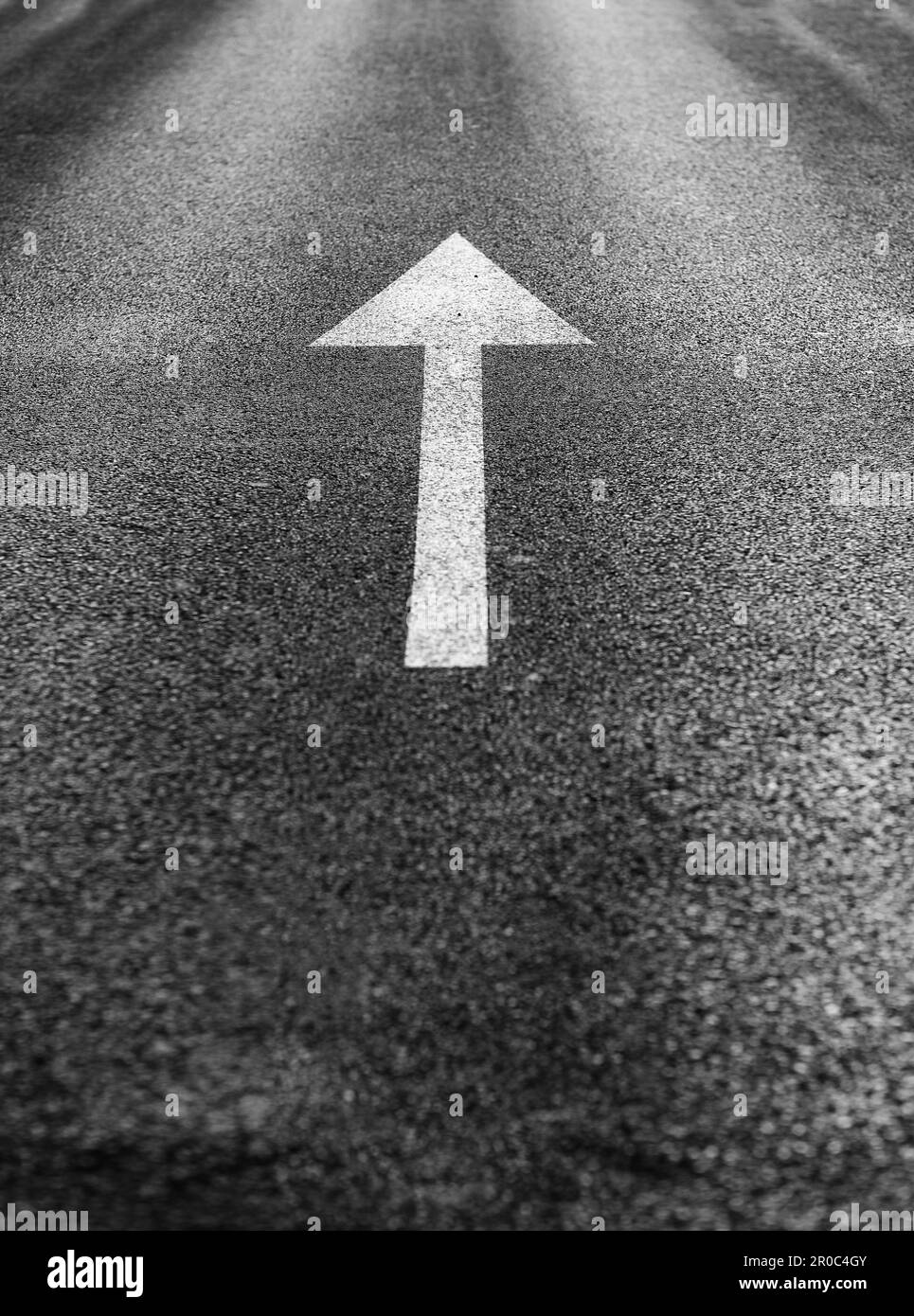 White arrow straight ahead direction of movement on dark asphalt ...