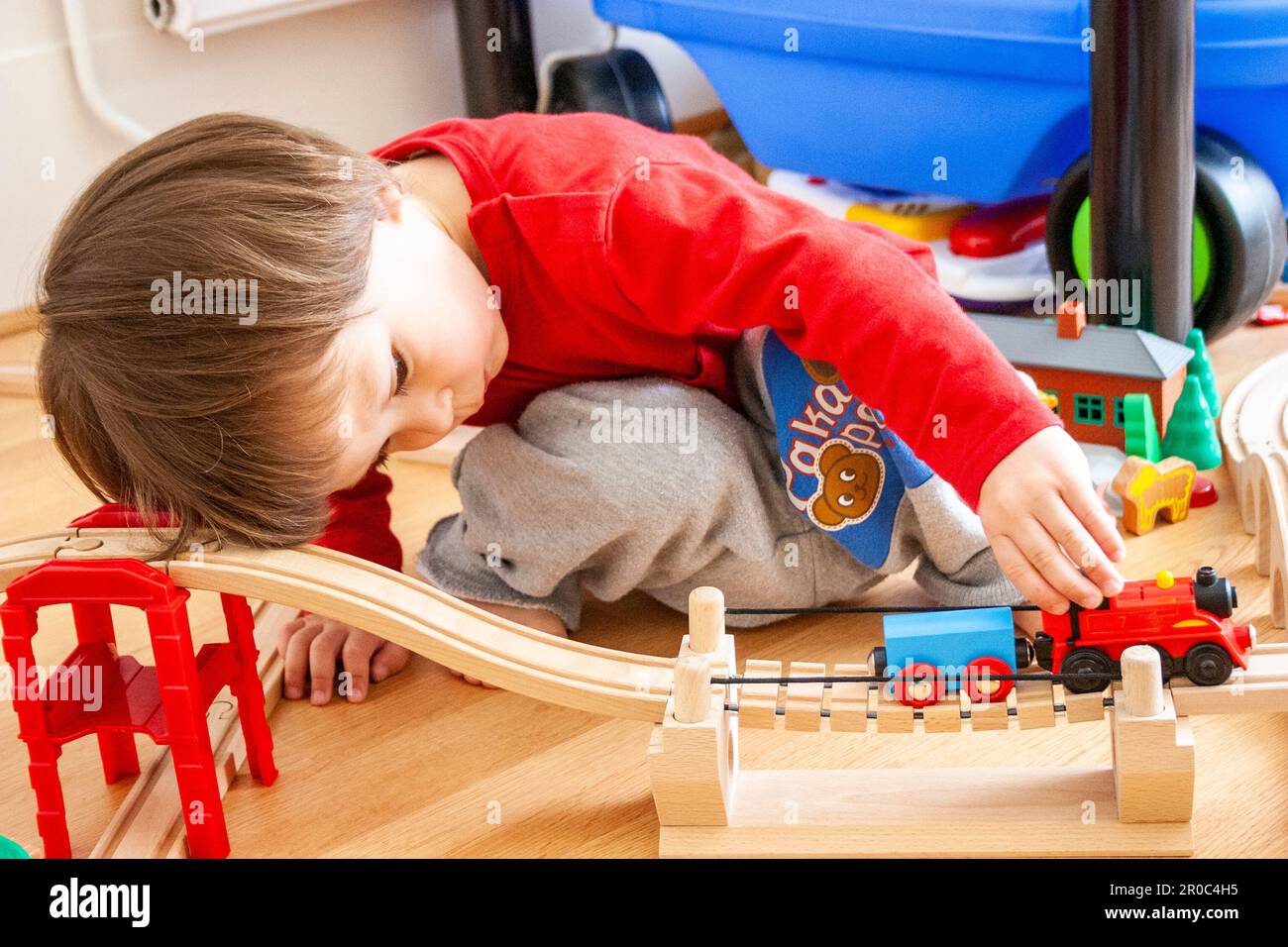 Close up of 2 year old Caucasian child, boy, crouching on a floor in a ...