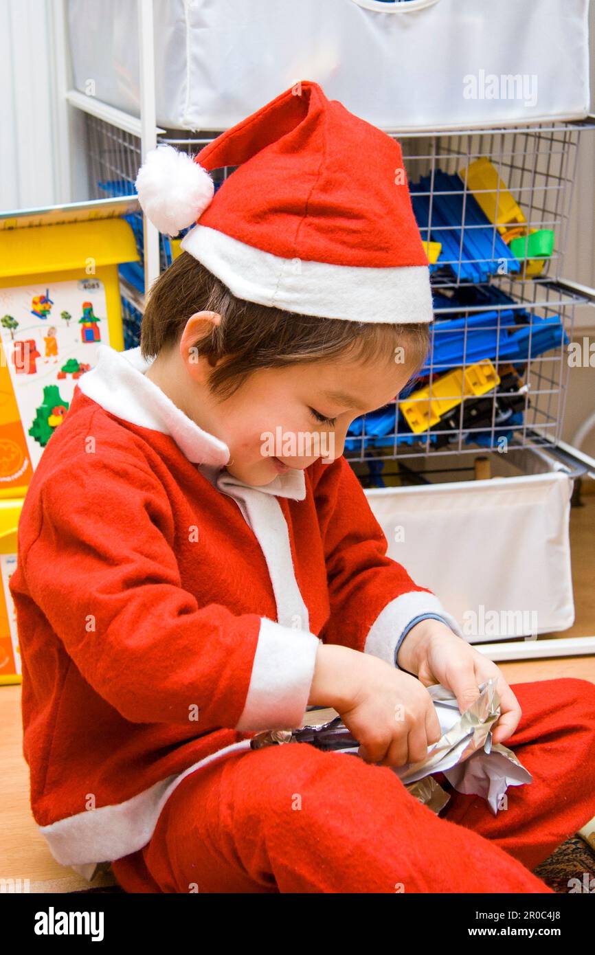 Close up, five year old child, boy, smiling, dressed in red Santa Claus ...
