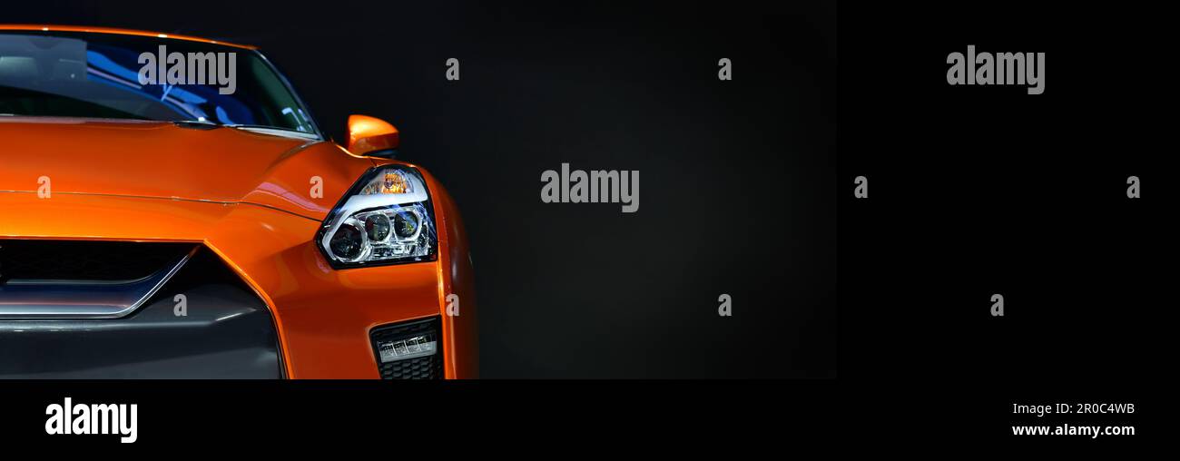 Detail on one of the LED headlights orange modern car on black ...