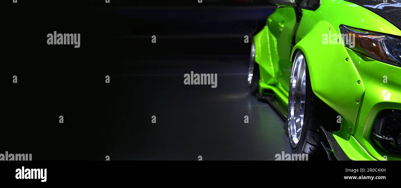 Front headlights of green modify car on black background, copy space ...