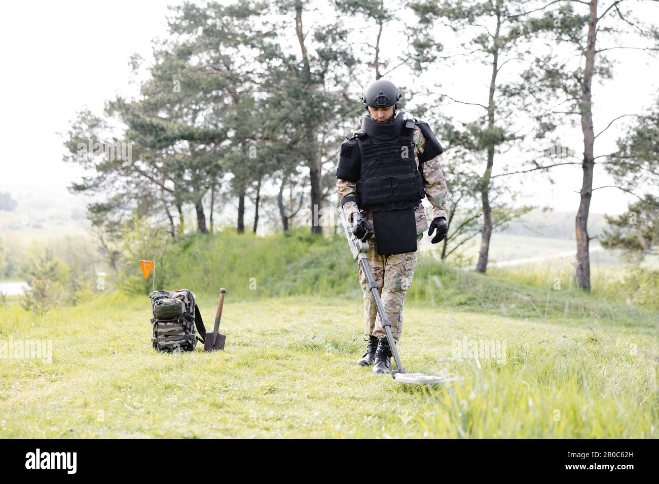 A man in a military uniform and bulletproof vest works in the forest ...