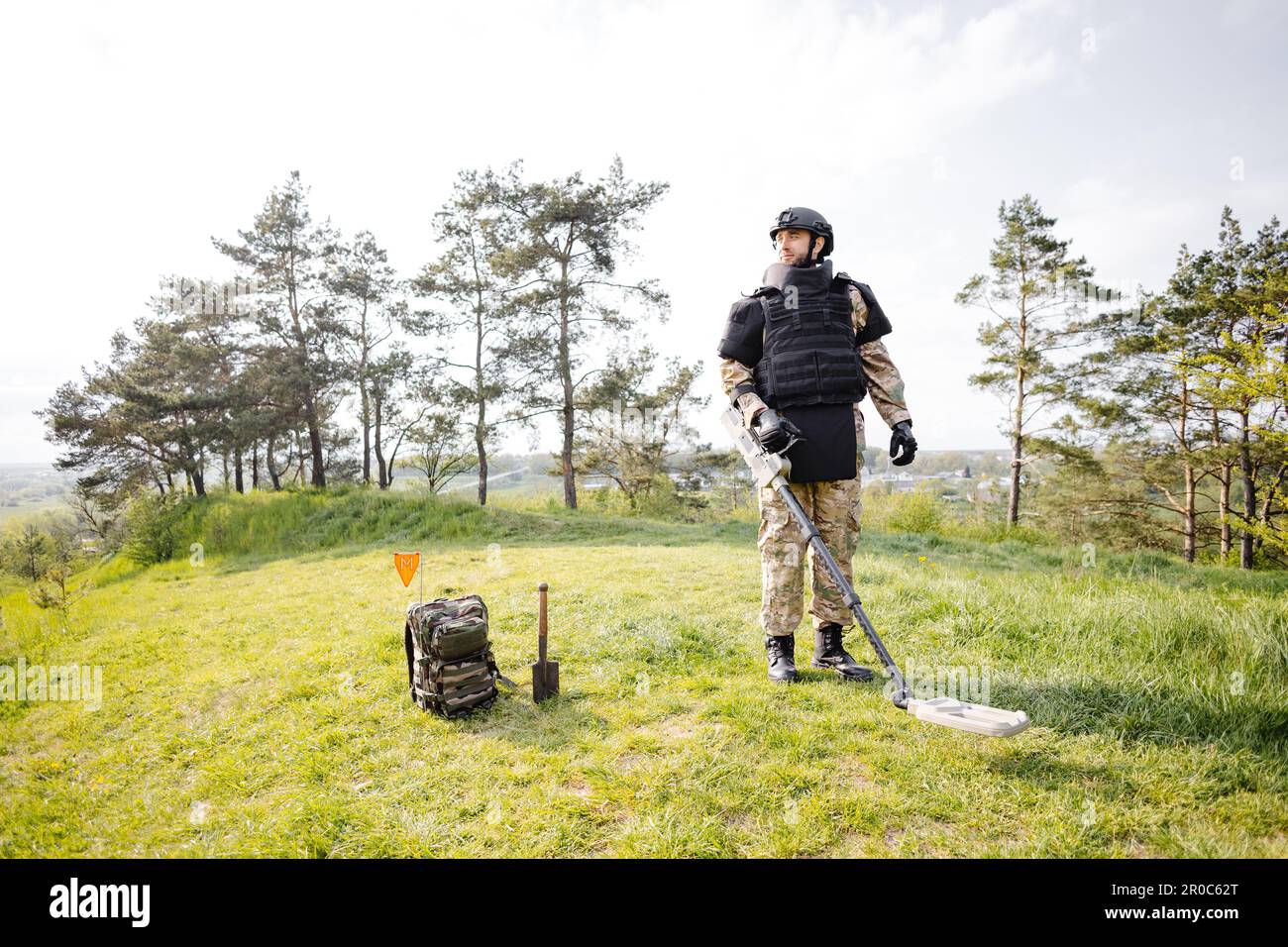 A man in a military uniform and bulletproof vest works in the forest ...
