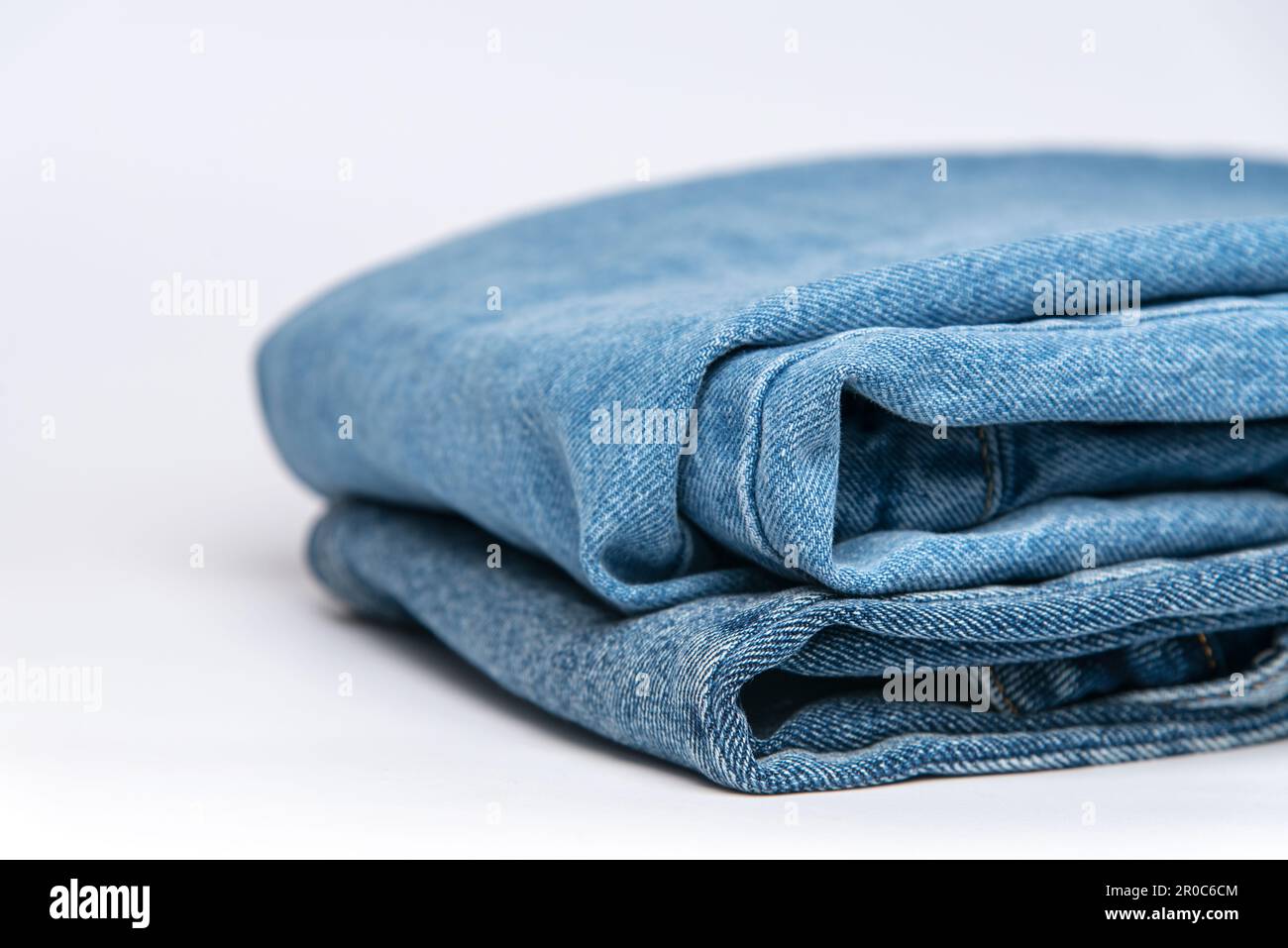 Stack of blue jeans on white background Stock Photo - Alamy