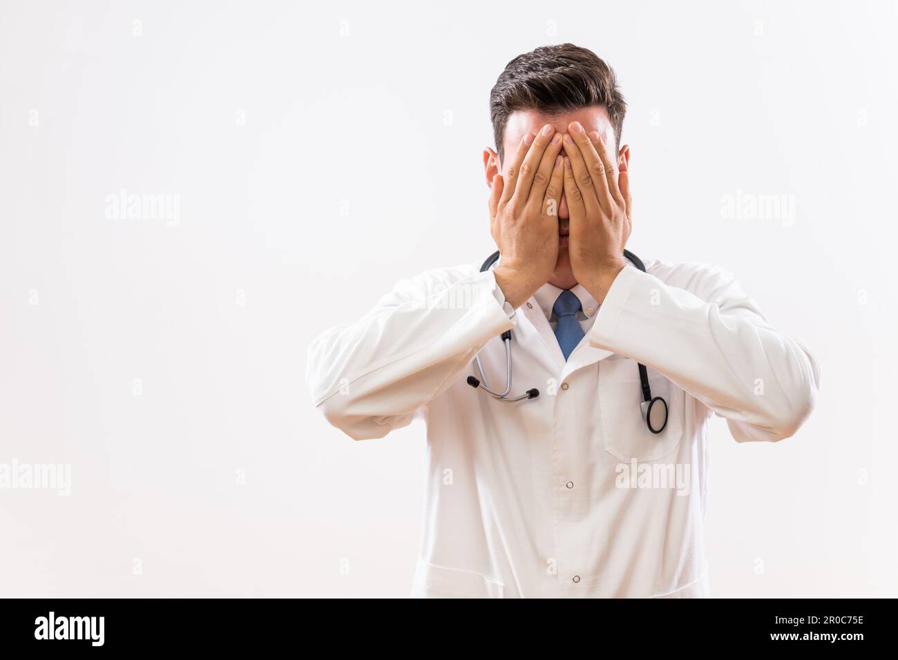Image of desperate doctor covering his face Stock Photo - Alamy