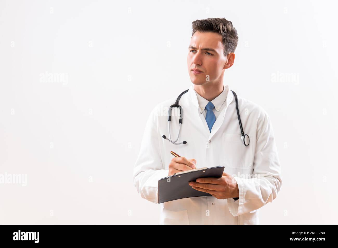 Image of pensive doctor writing notes Stock Photo - Alamy