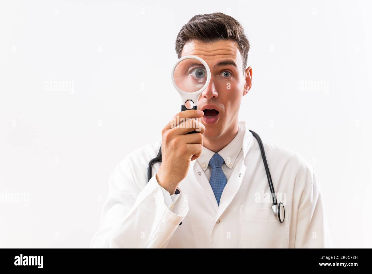 Image of shocked doctor looking through loupe Stock Photo - Alamy