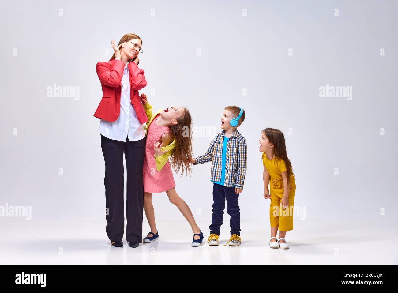 Rest needed. Portrait of young woman covering ears to avoid noisy kids ...