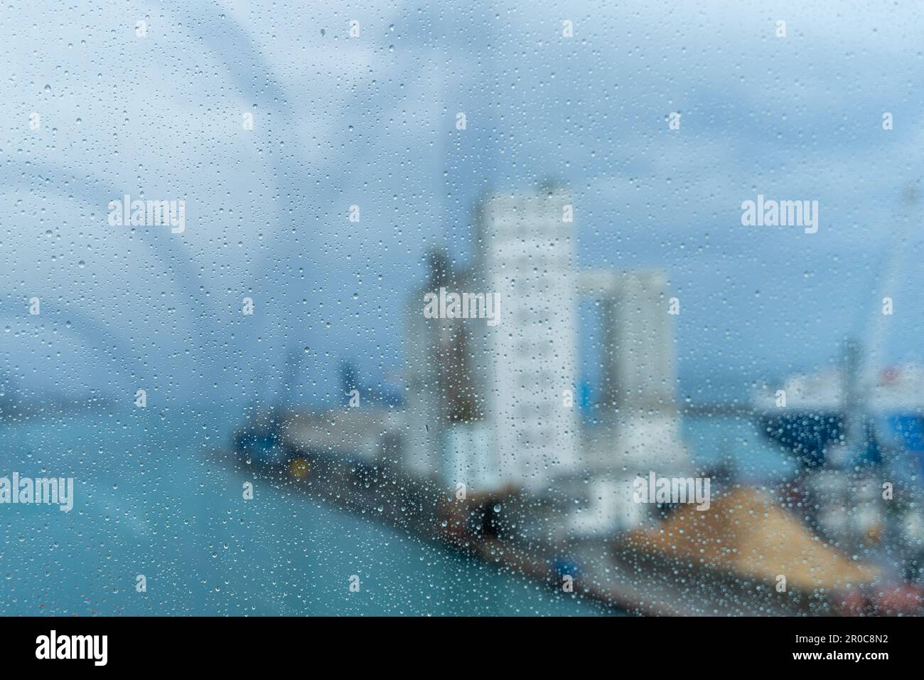 buildings on a blurry harbor quay seen from a cruise ship through a ...