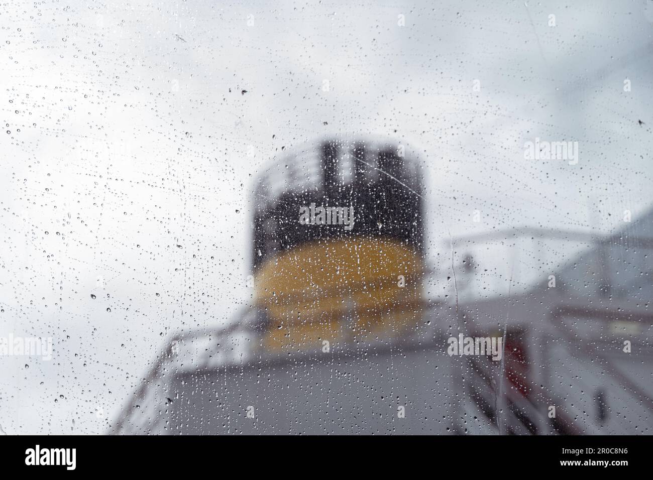 defocused yellow chimney of a cruise ship seen through a window glass ...