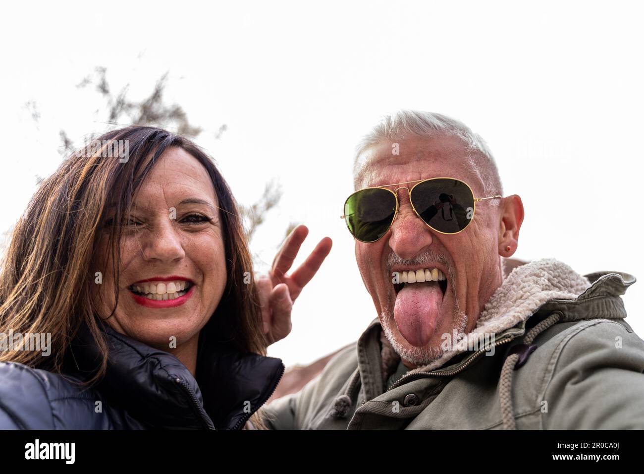 happy middle aged couple taking a selfie showing victory sign in a ...