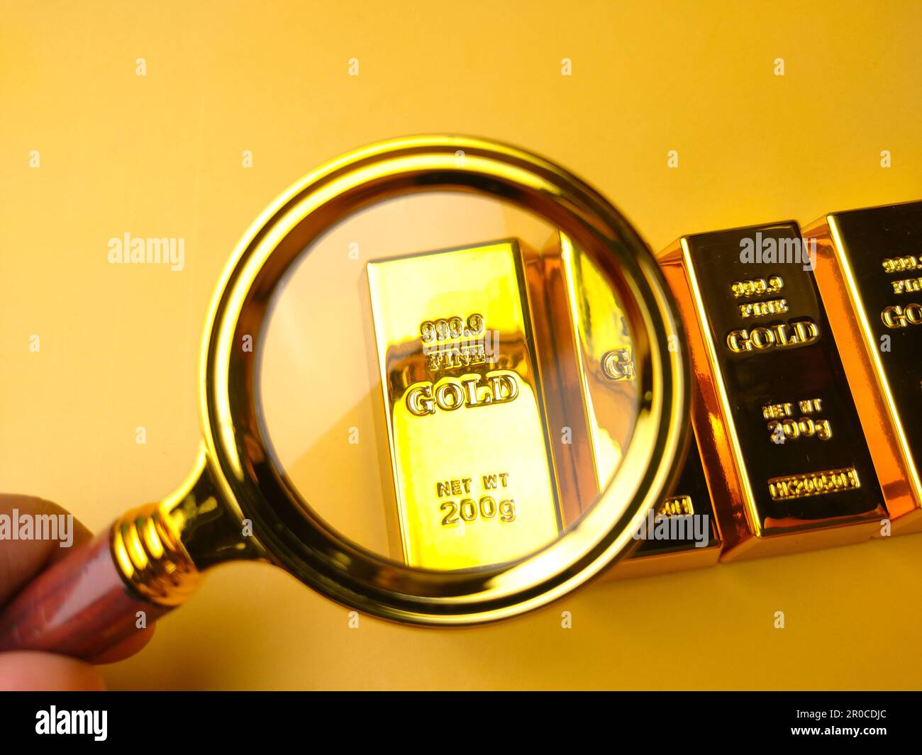 Vintage magnifying glass and gold bar on a yellow background Stock ...