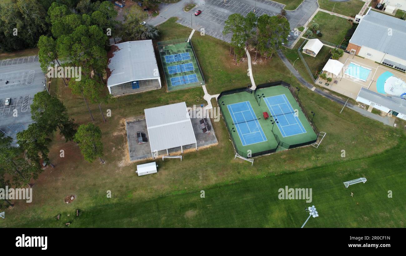 An aerial view of sports complex featuring tennis courts and swimming ...