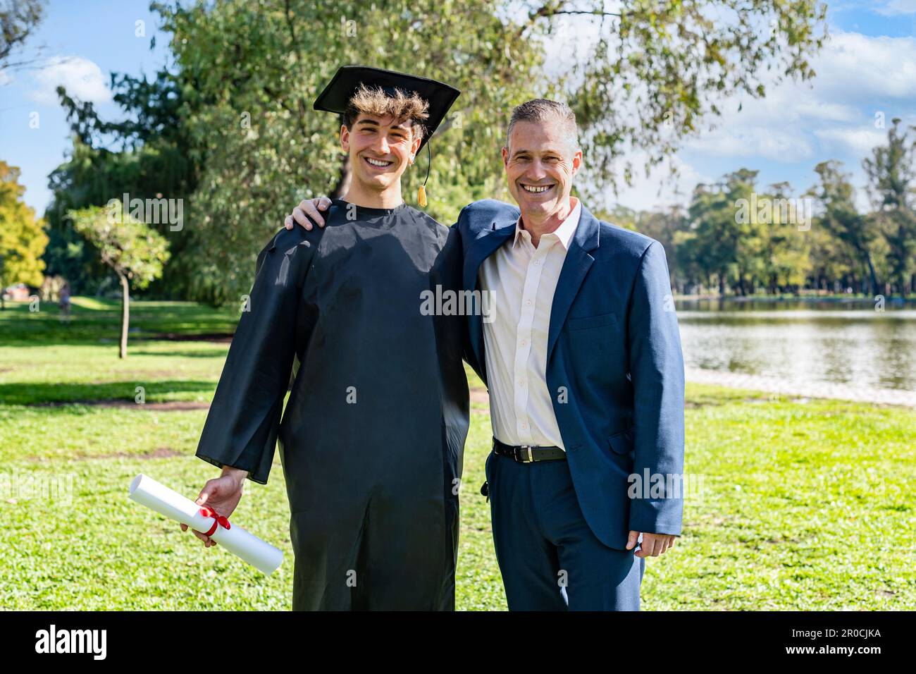 Portrait of a happy caucasian graduated young man with his father on ...