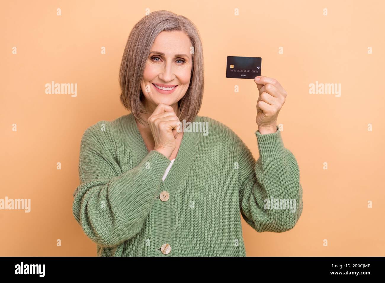 Portrait of minded smart aged lady arm touch chin hold plastic debit ...