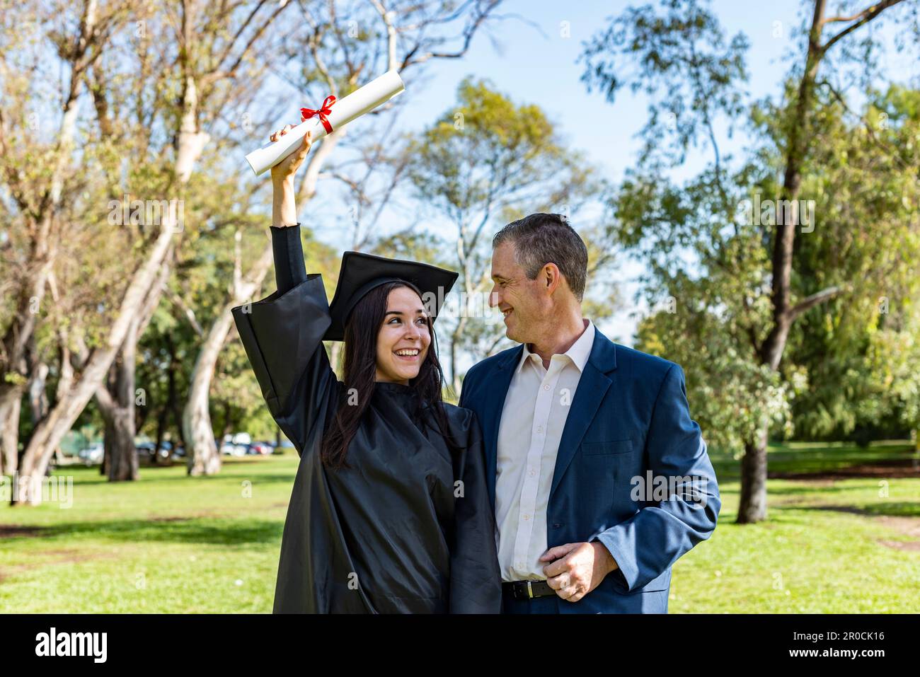 Happy caucasian graduated girl with her father on her graduation day ...