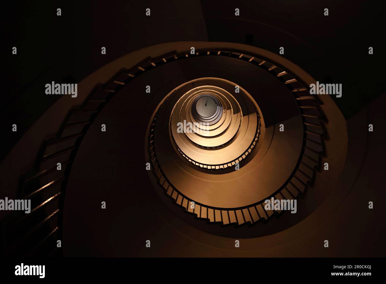 Spiral staircase in a tall multi-floor house, in the form of a "golden ...