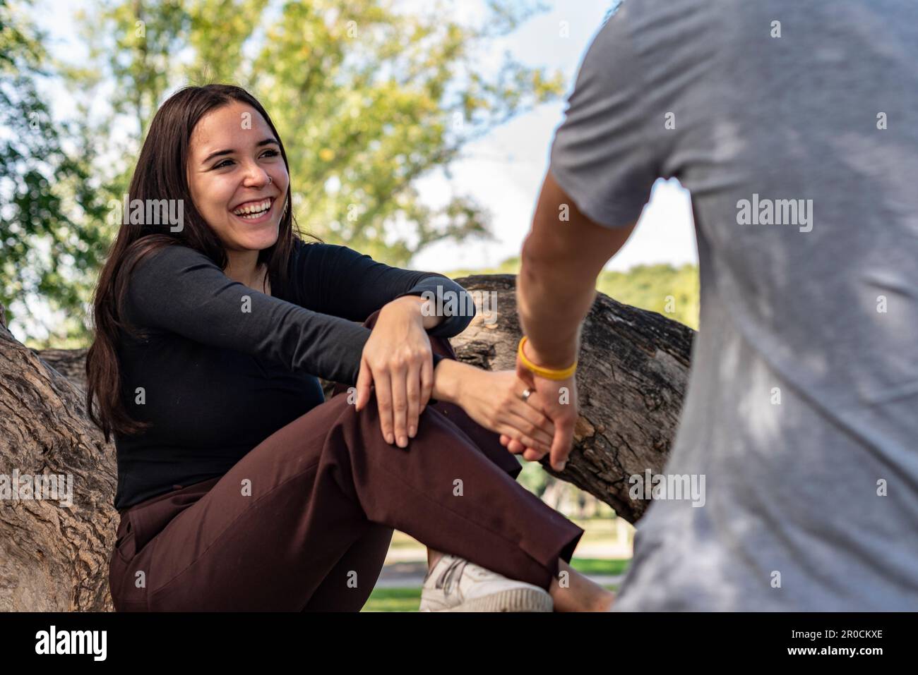 Young man takes the hand of a beautiful girl asking her to go with him ...