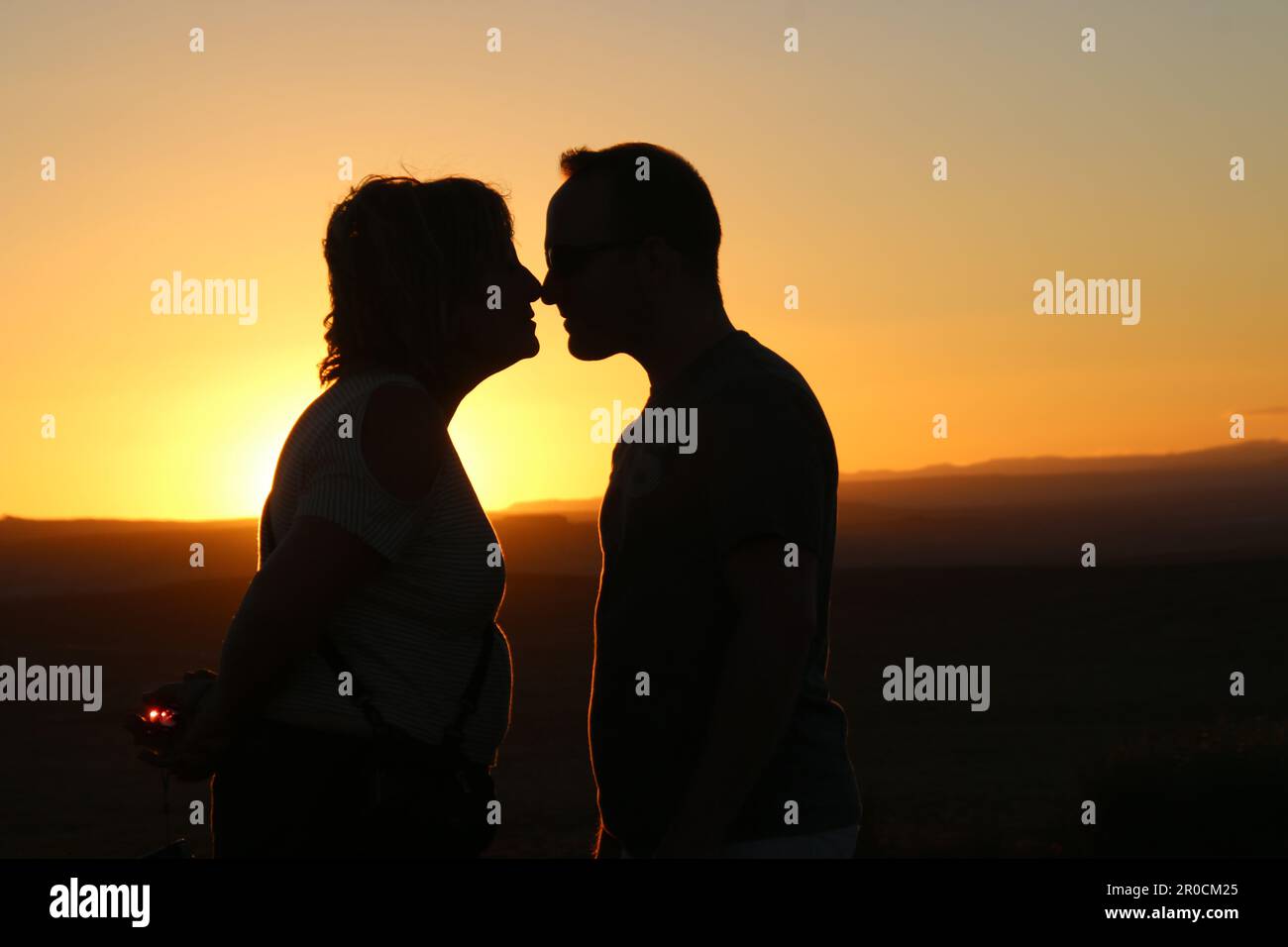 Silhouette of a couple facing each other at sunset Stock Photo - Alamy