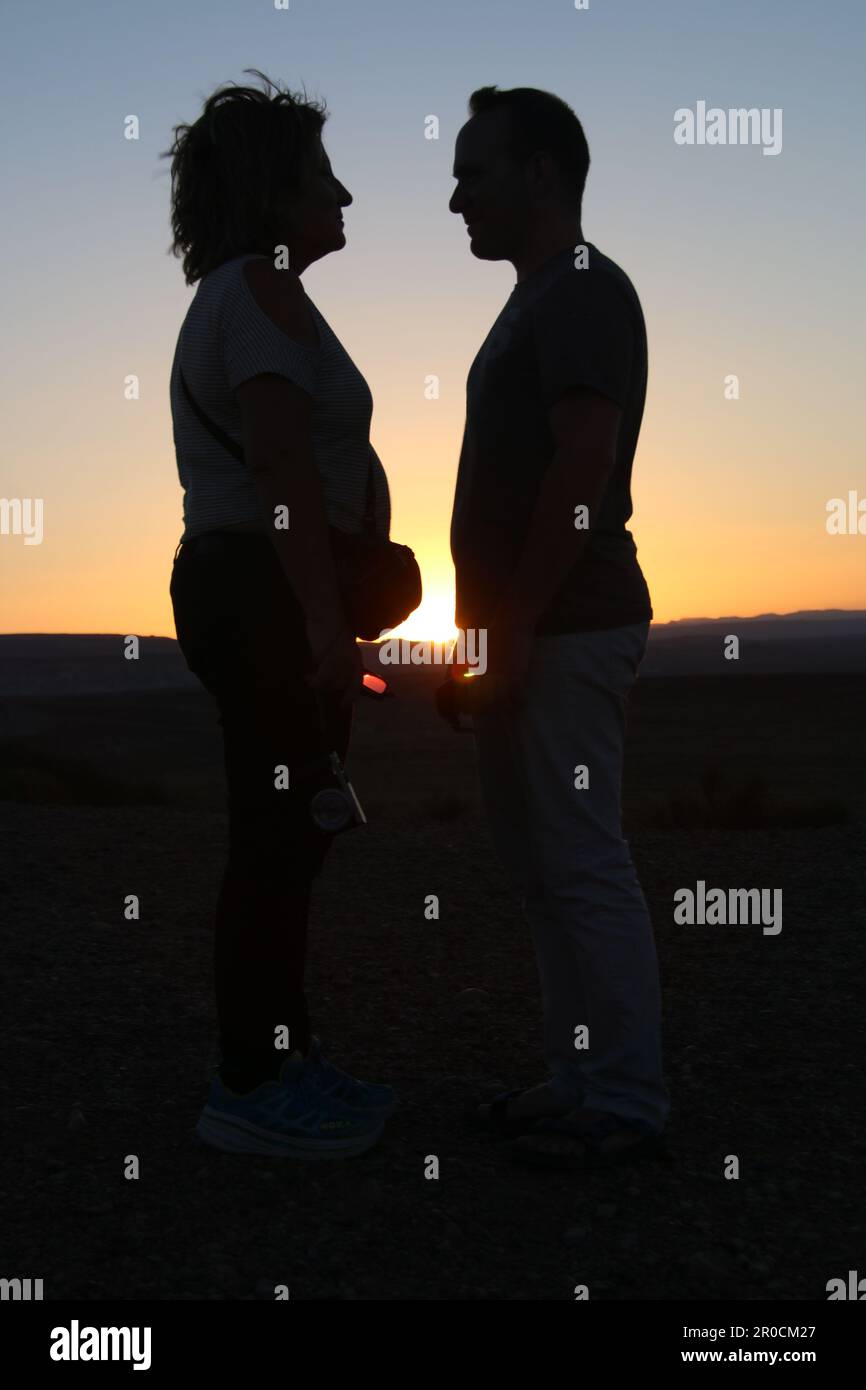 Silhouette of a couple facing each other at sunset Stock Photo - Alamy