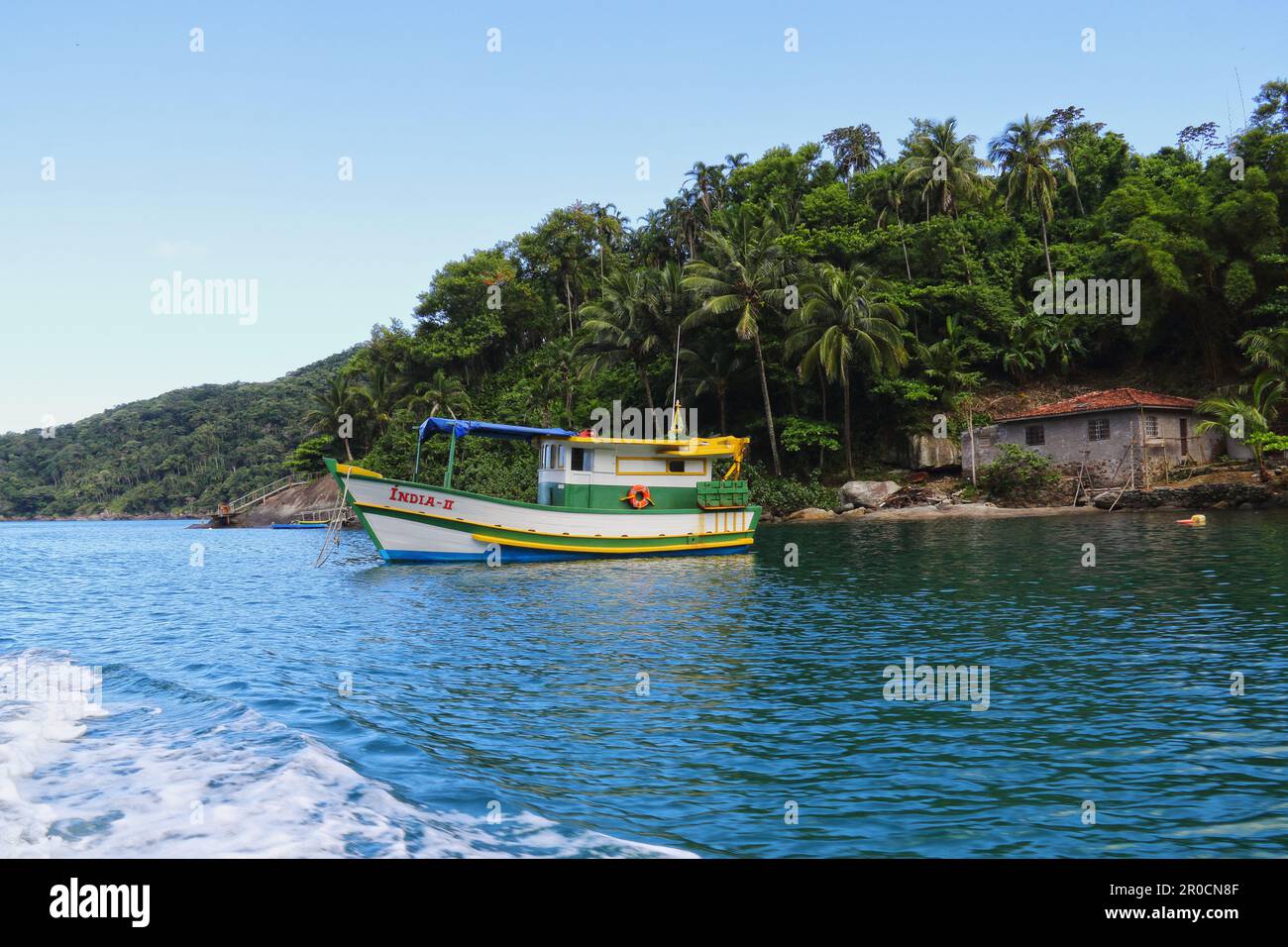 A boat floating on the surface of a tranquil blue body of water on the ...