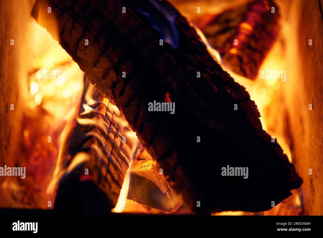 An open fireplace burning brightly in a dark room, the flickering ...