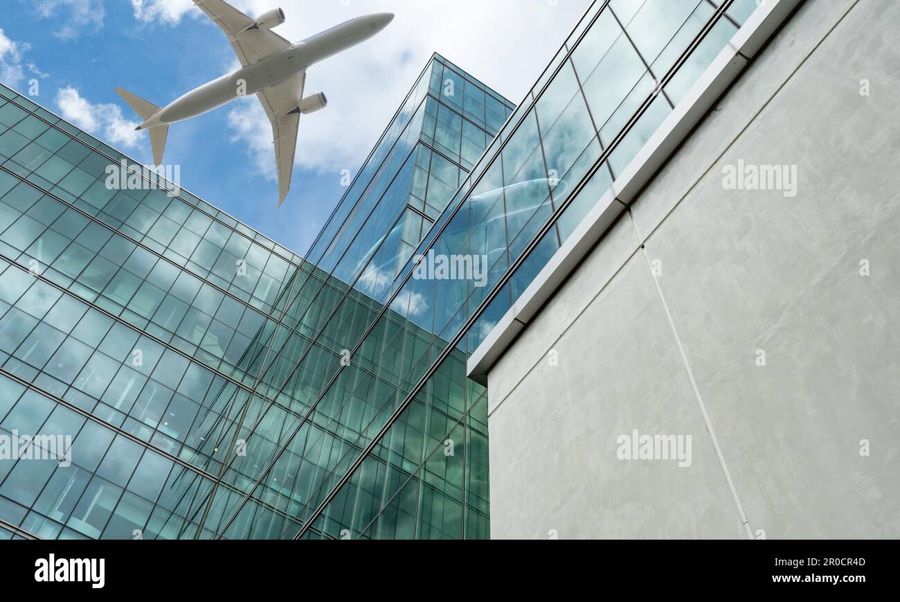 Airplane flying above modern office building. Exterior facade of ...
