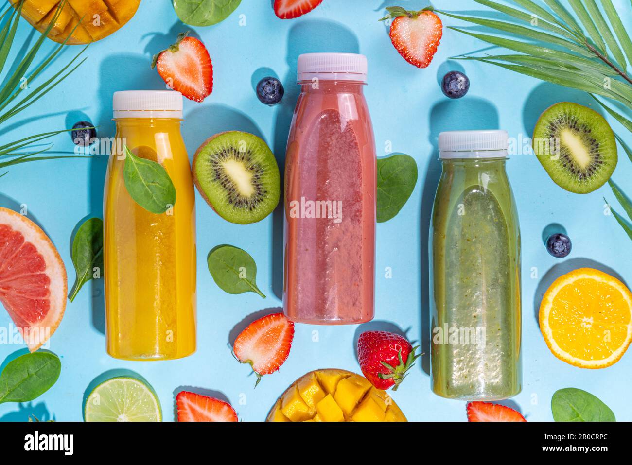 Green, orange and red smoothie in portion bottles, Mix of colourful ...