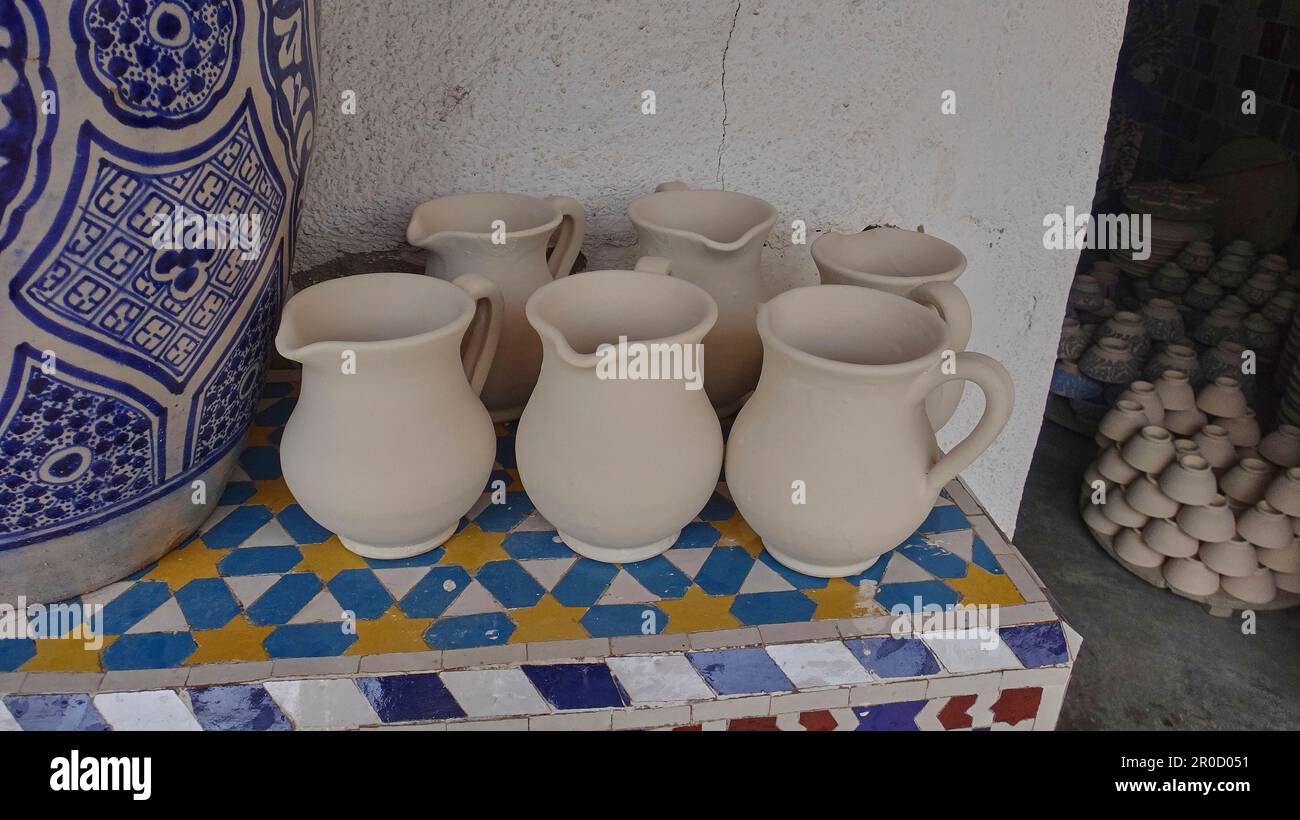 handcrafted ceramic pottery jugs made out clay standing on a colorful ...