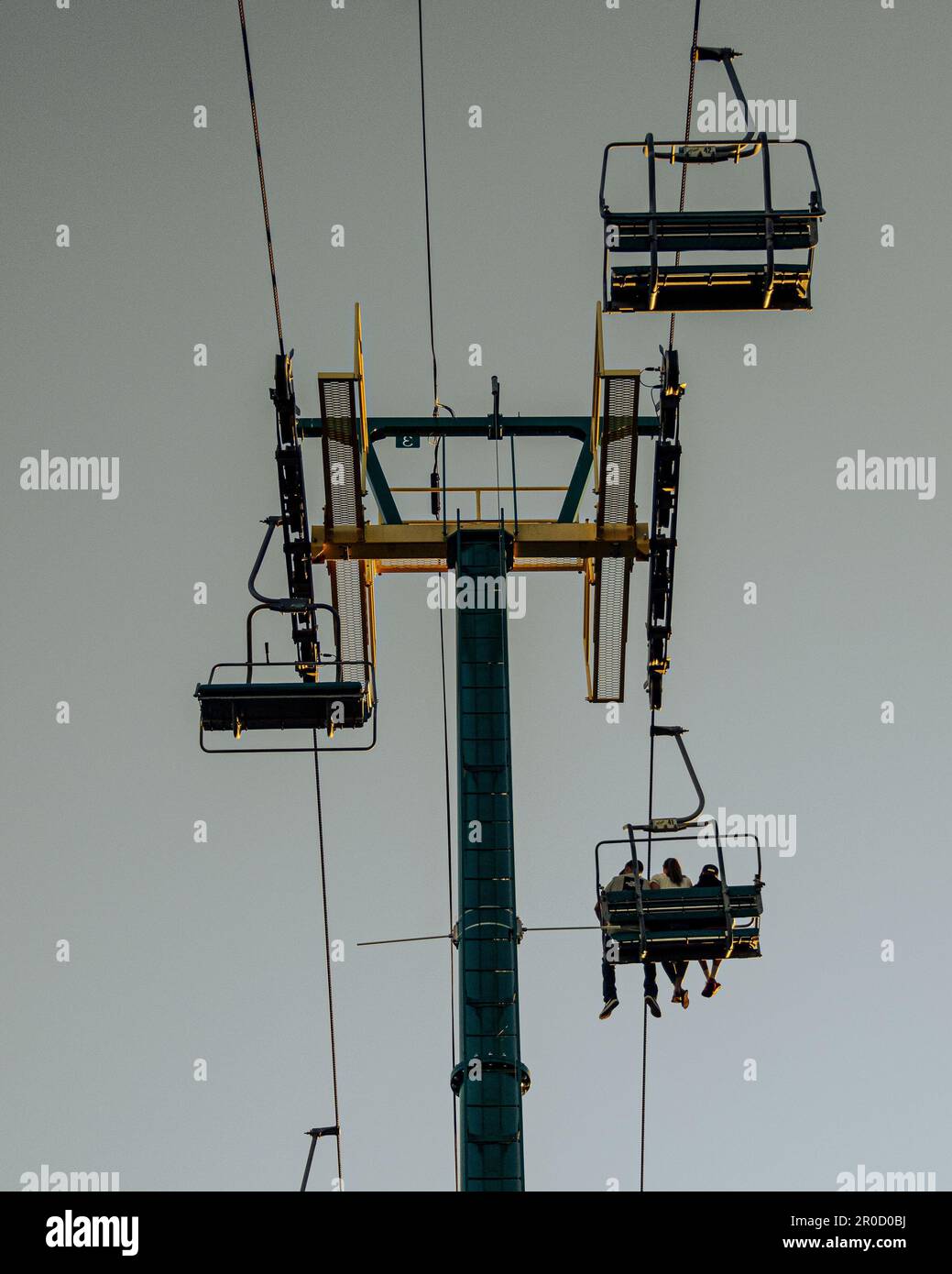Two people enjoying the ski lift ride, soaring through the air above a ...