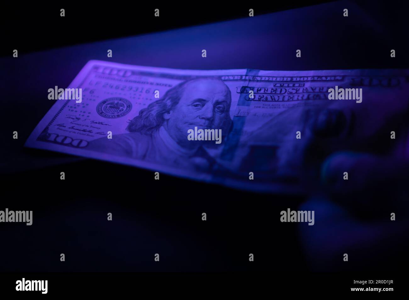 Close-up of dollars under an ultraviolet lamp. Inspection of a dollar ...