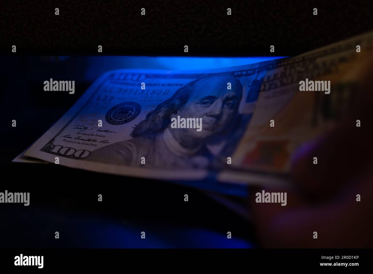 Close-up of dollars under an ultraviolet lamp. Inspection of a dollar ...