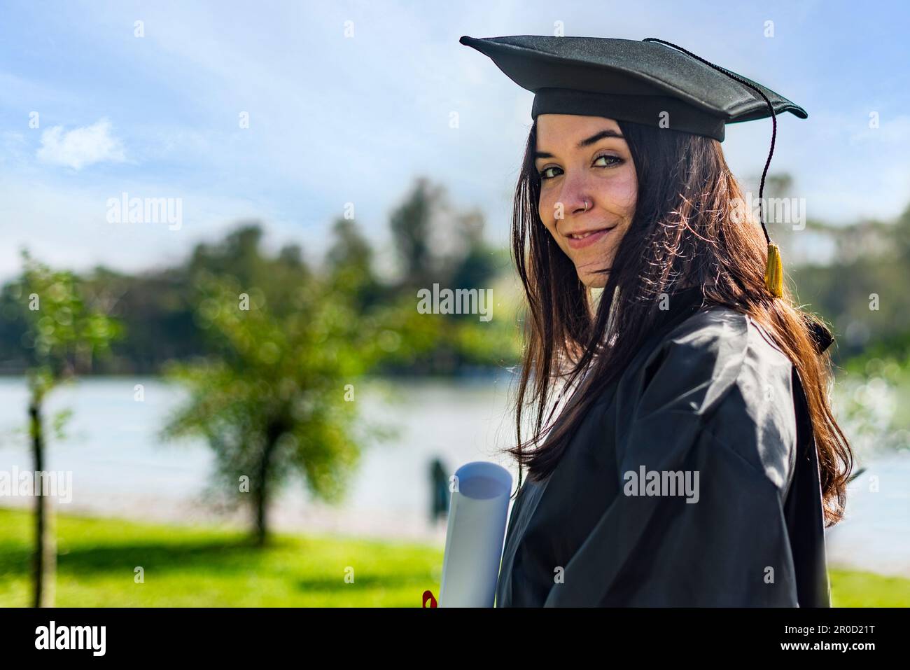Happy caucasian graduated girl with long brown hair, holding a diploma ...