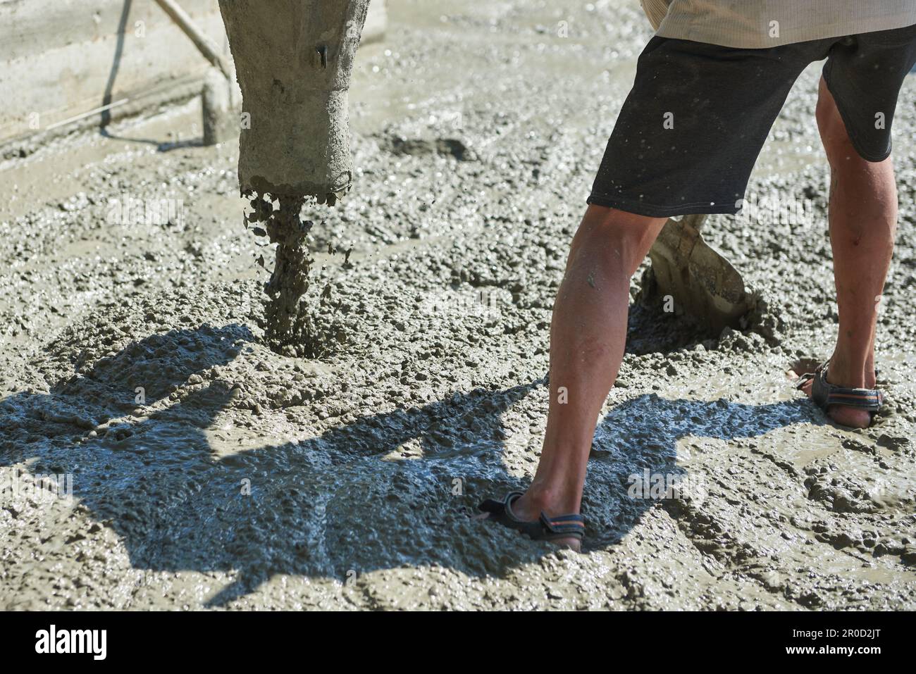 Builder standing in a concrete mortar, heavy construction work Stock ...