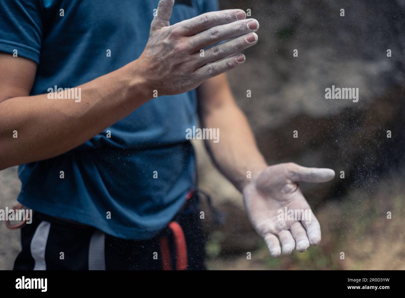 A Male Wearing A Blue T Shirt Dusting Off His Hands That Are Covered With White Powder Stock