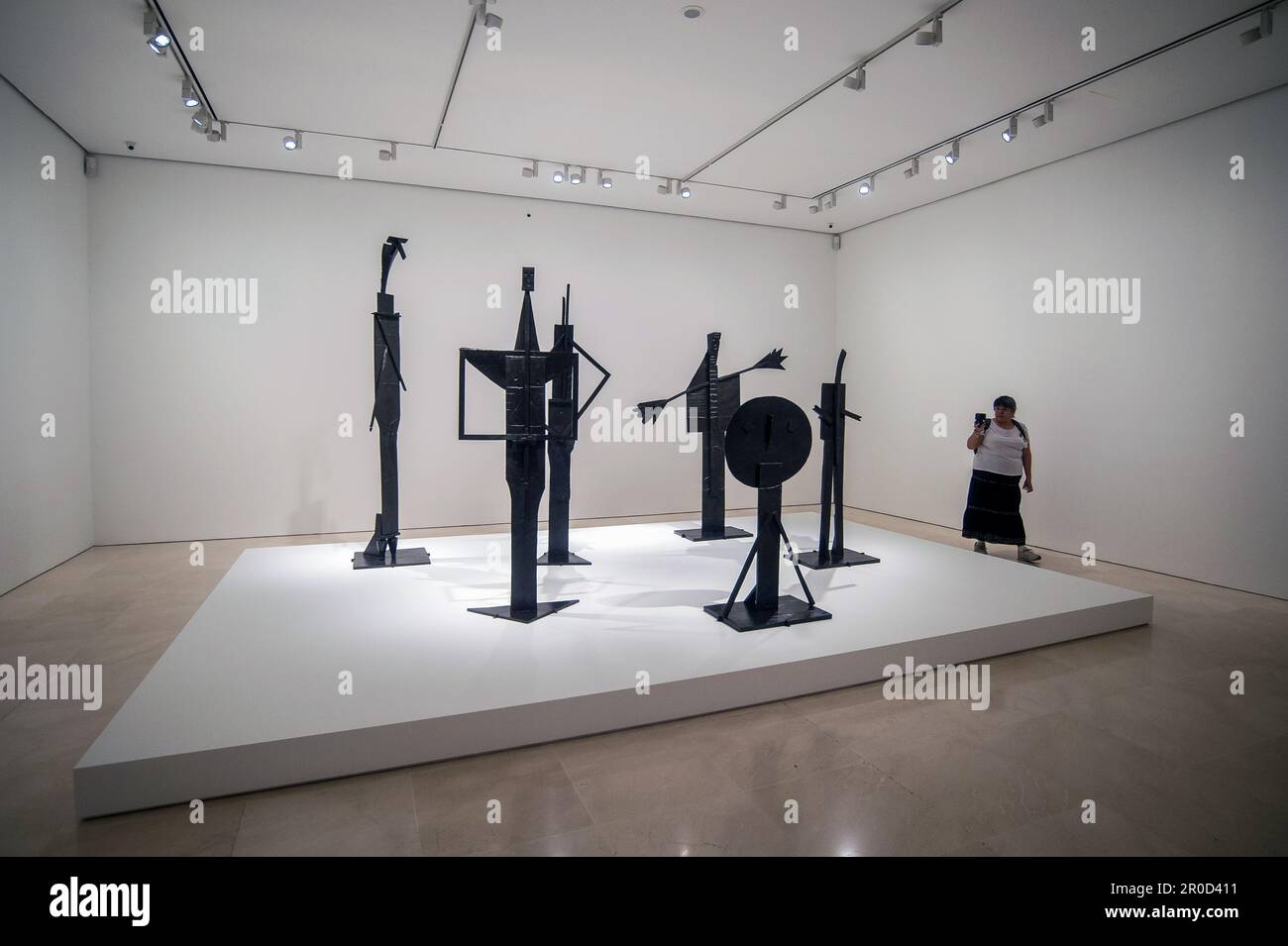 A woman records a video of sculptures during the presentation of the ...
