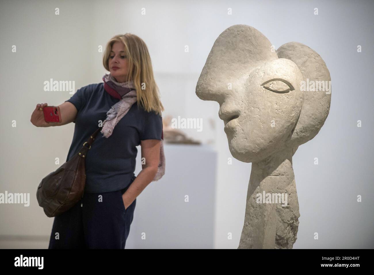 A woman takes a selfie next to a sculpture during the presentation of ...