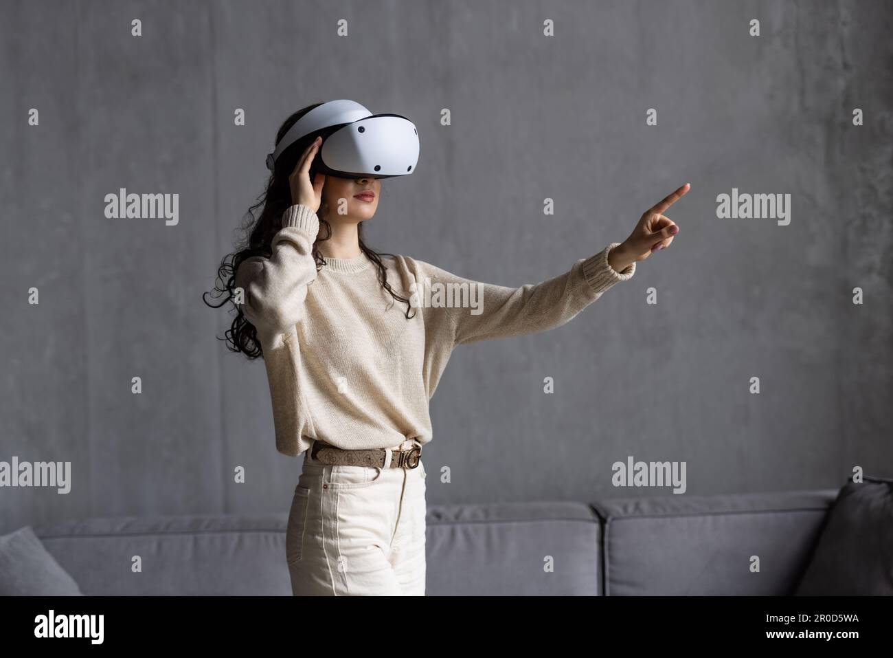 happy young woman wearing virtual reality technology device sitting on ...