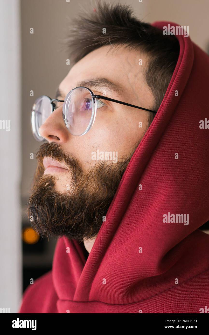 Side view of man longing and looking through window in sad day ...