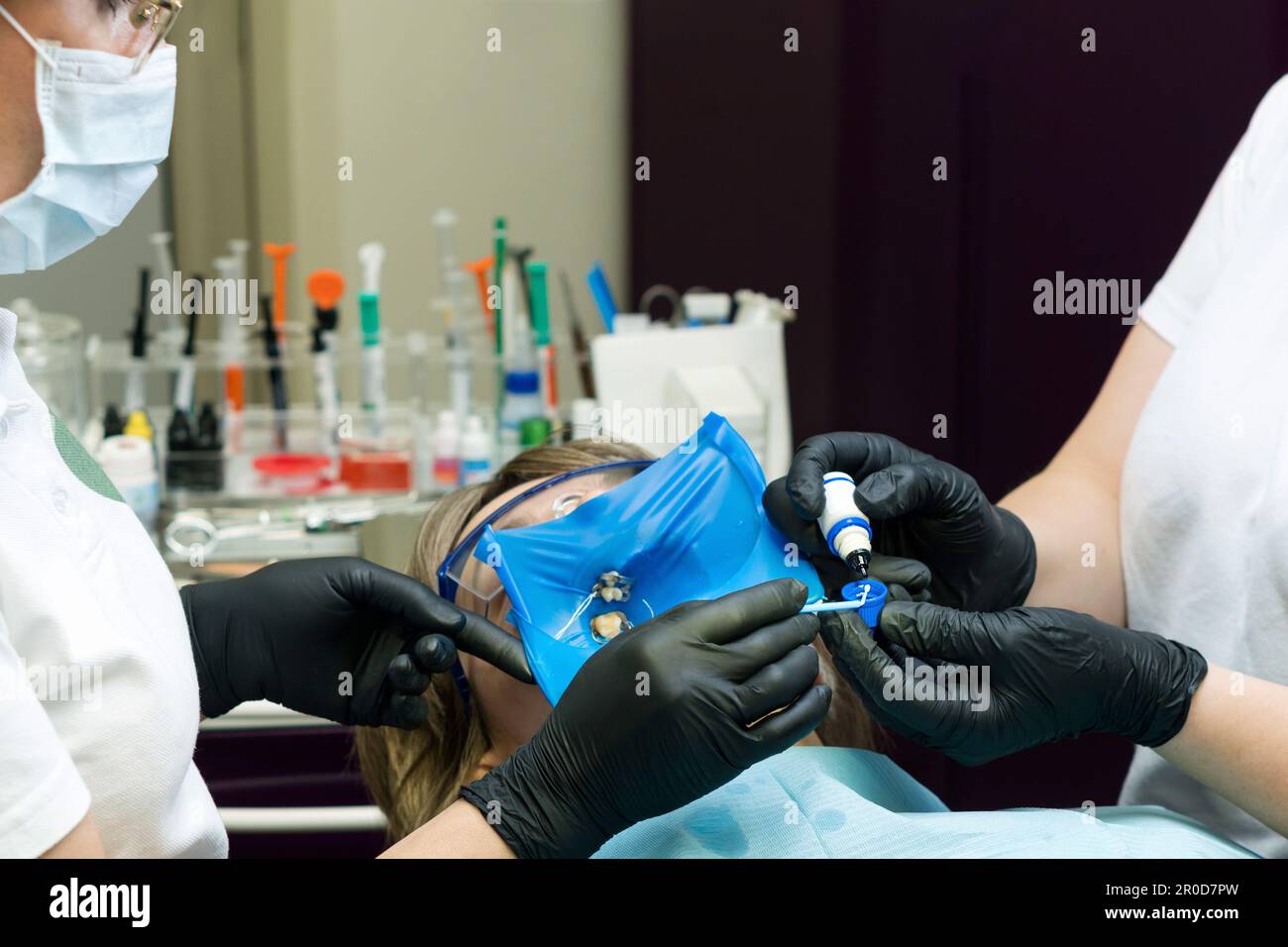 Doctor and help assistant using of rubber dam system with latex scarves ...