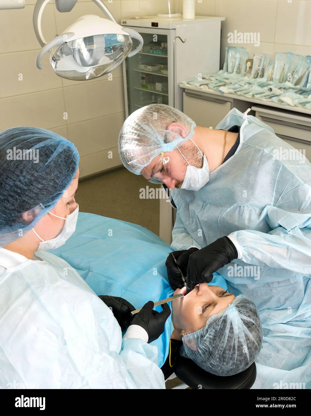 Surgeon and nurse during dental operation. Local anesthetized female ...