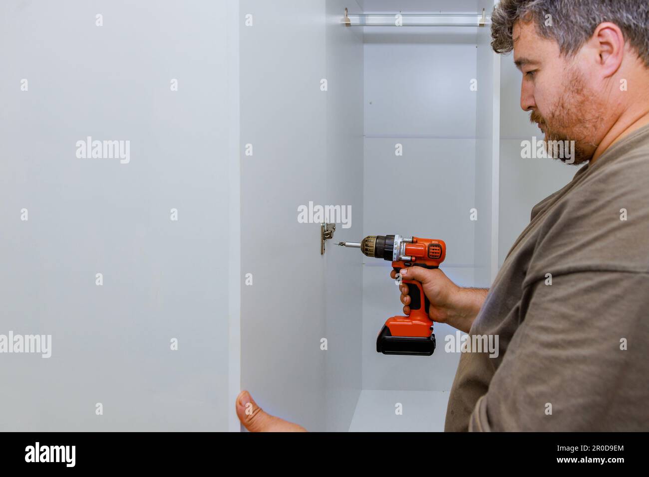 Carpenter was assembling furniture closet cabinets that needed to be ...