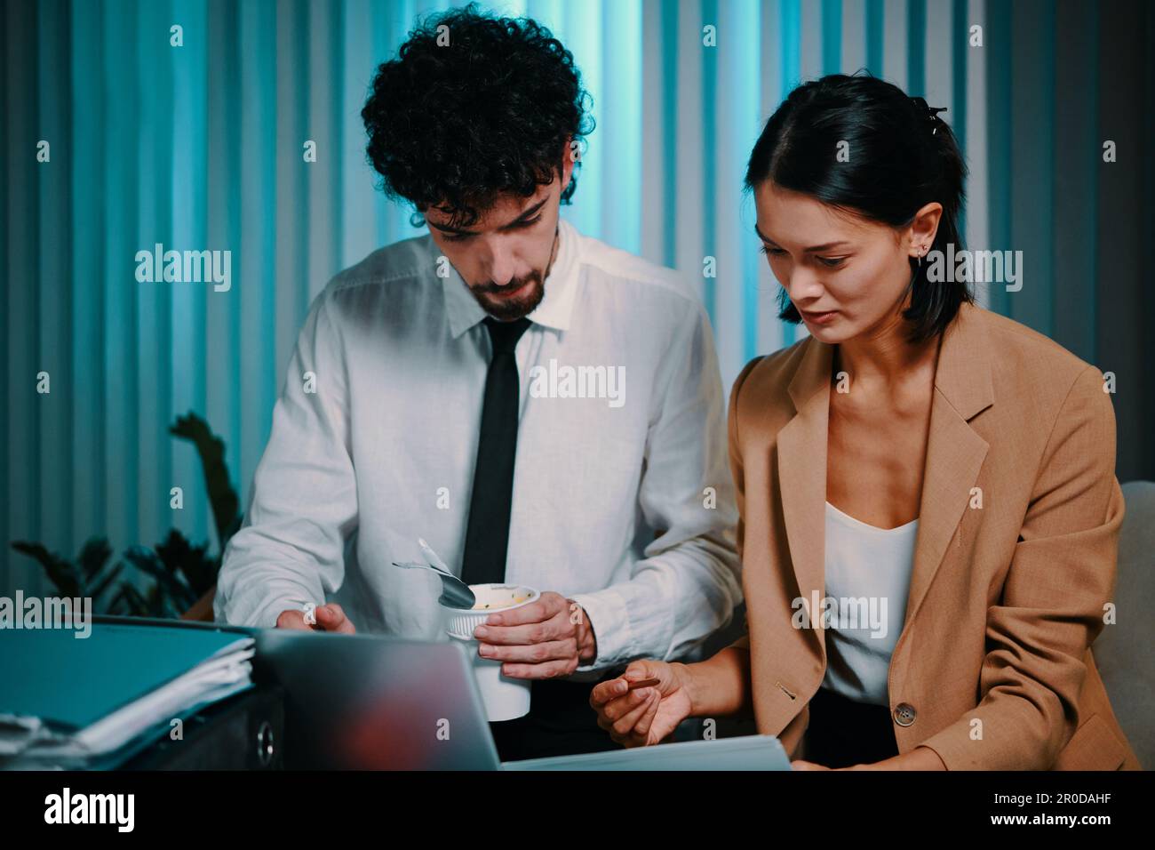 Businessman eating instant noodle when helping colleague to finish work ...