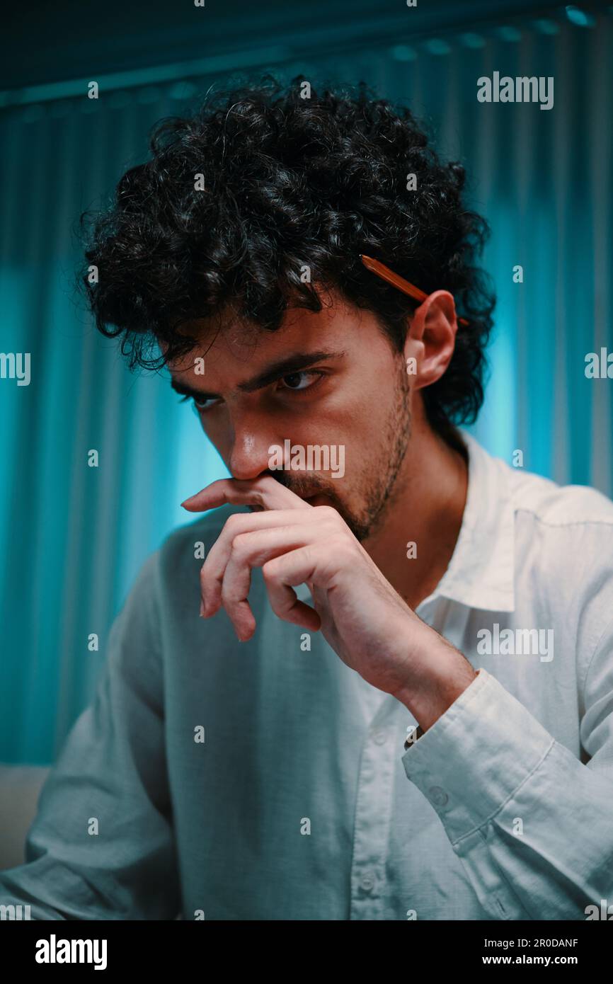 Serious businessman with pen behind his ear reading specifications ...