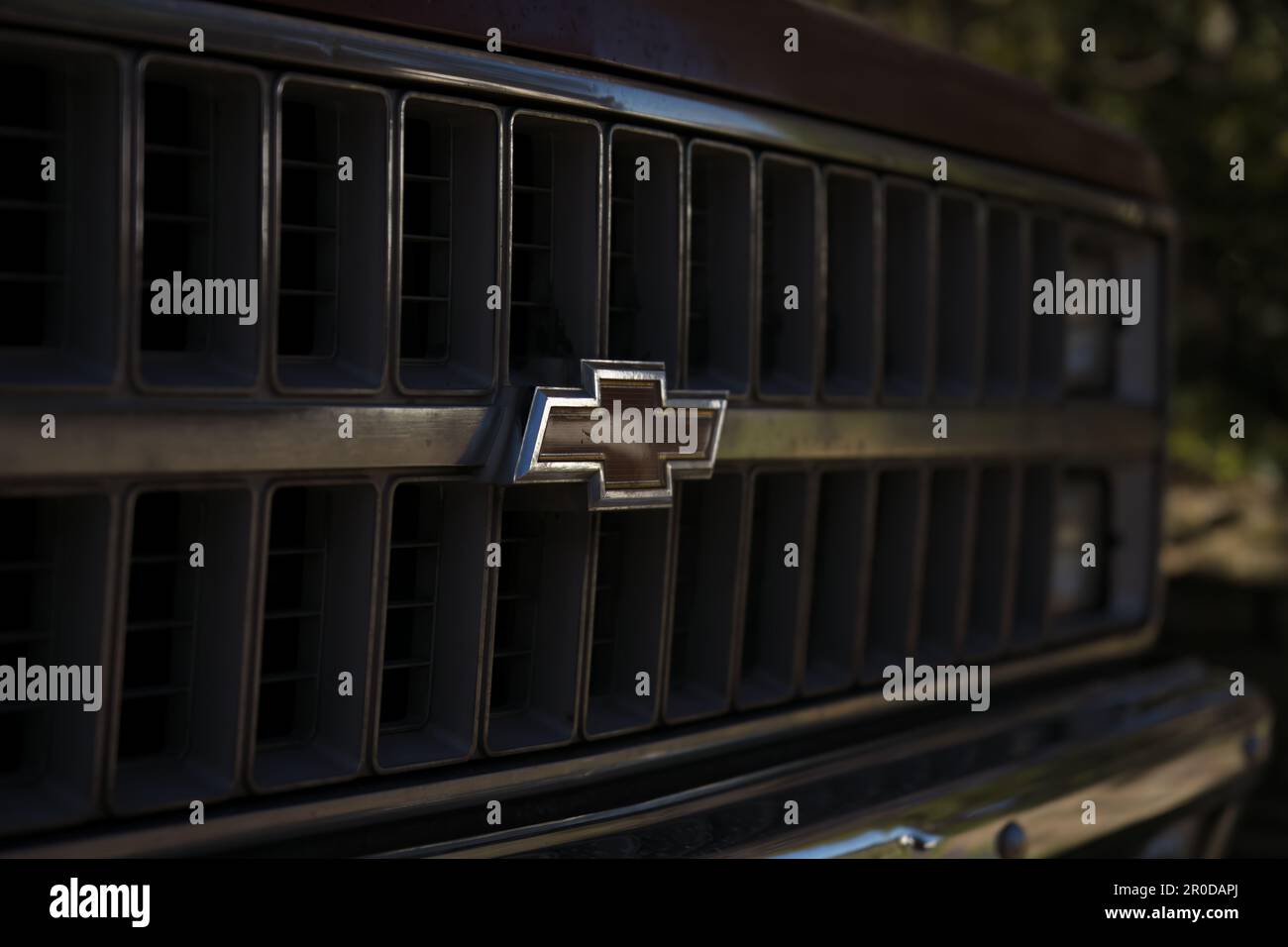 A close-up of the Chevrolet logo on the grille of a car, in focus with ...