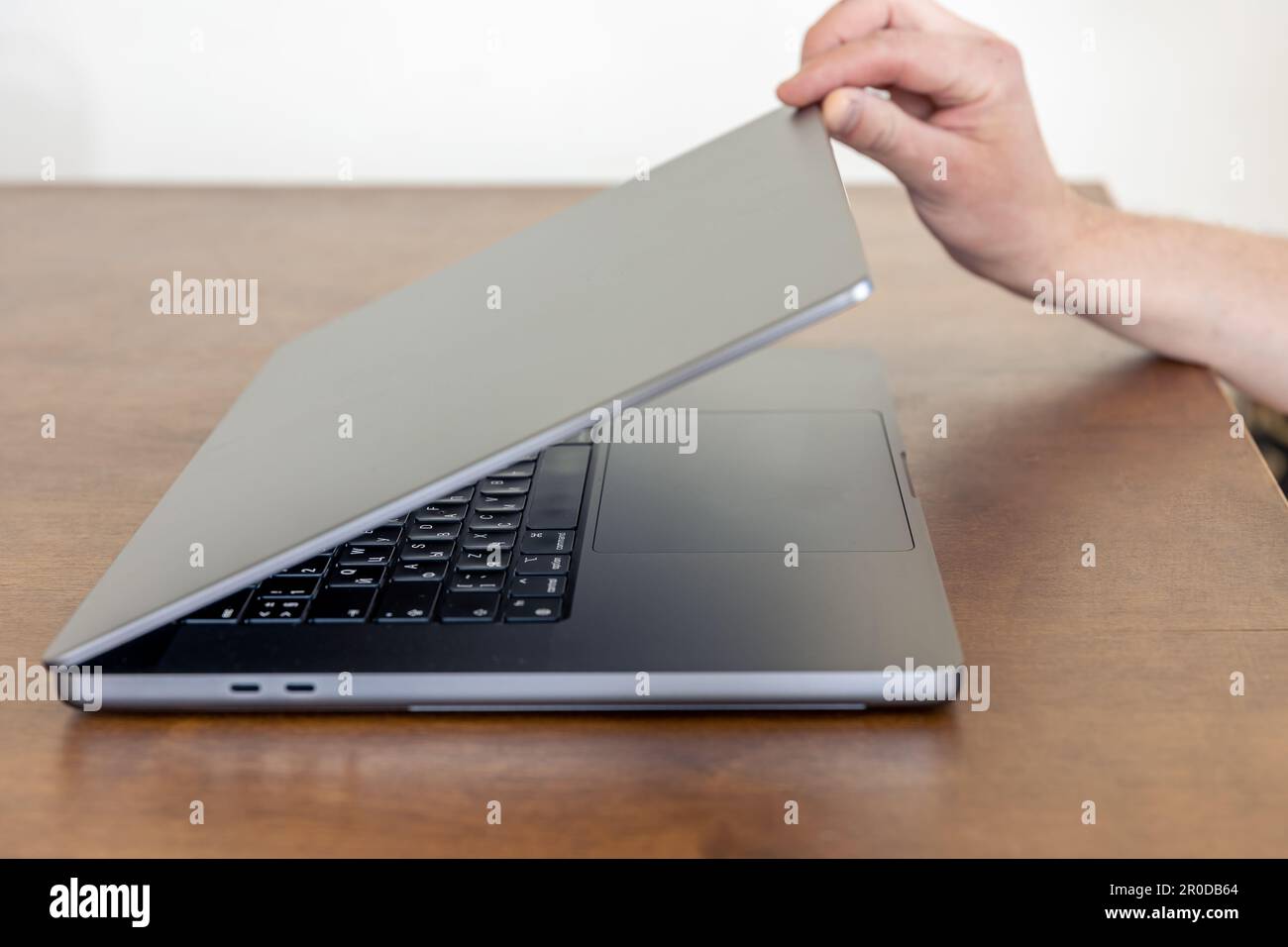 A man's hand opens a laptop with a multi-colored glowing screen Stock ...