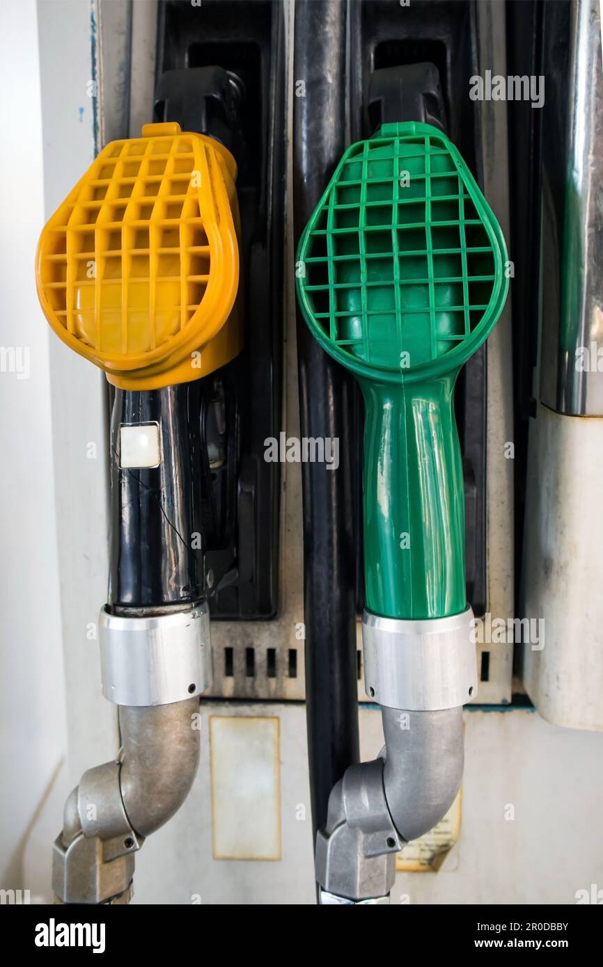 Green and yellow colored fuel pump hanging at the station,vertical ...