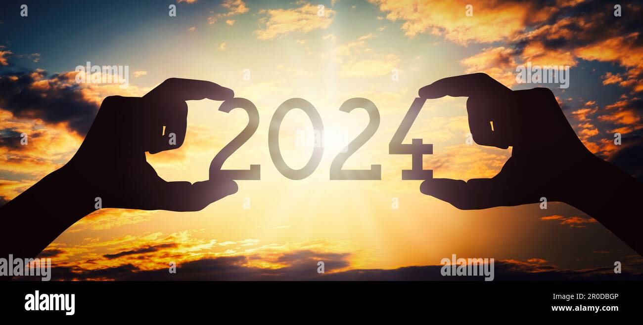2024 - human hands holding black silhouette year number Stock Photo - Alamy