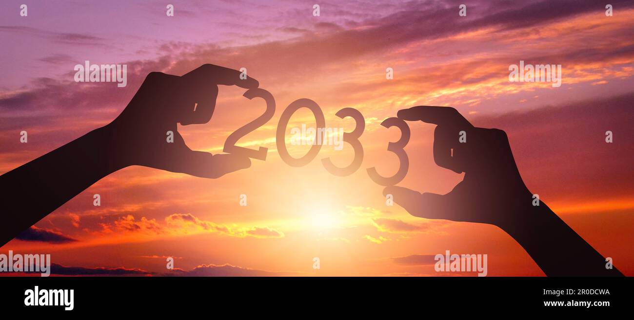 2033 - human hands holding black silhouette year number Stock Photo - Alamy